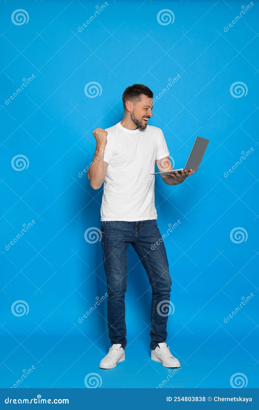 Happy Man Looking at Laptop on Light Blue Background Stock Photo ...