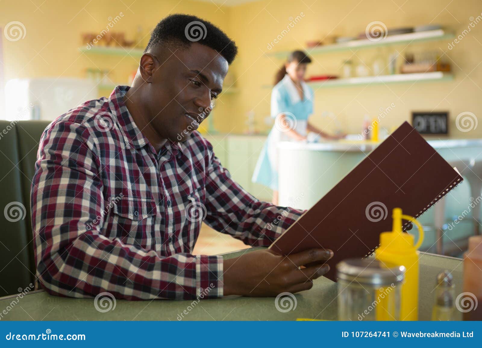 Man Looking at Menu in Restaurant Stock Image - Image of female ...