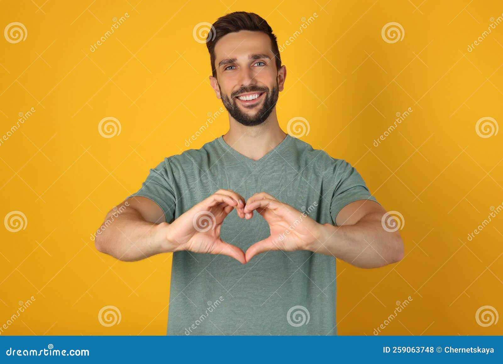 Happy Man Making Heart with Hands on Yellow Background Stock Photo ...