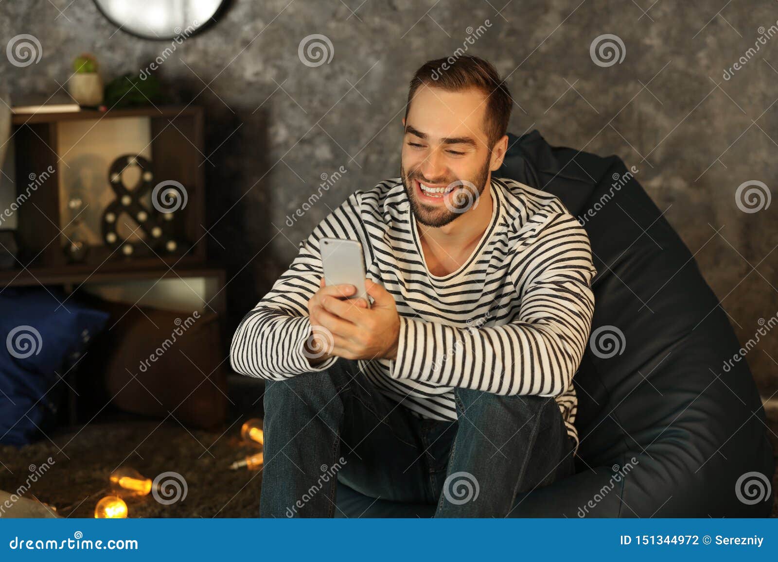 Happy Man with Mobile Phone Sitting at Home Stock Photo - Image of ...