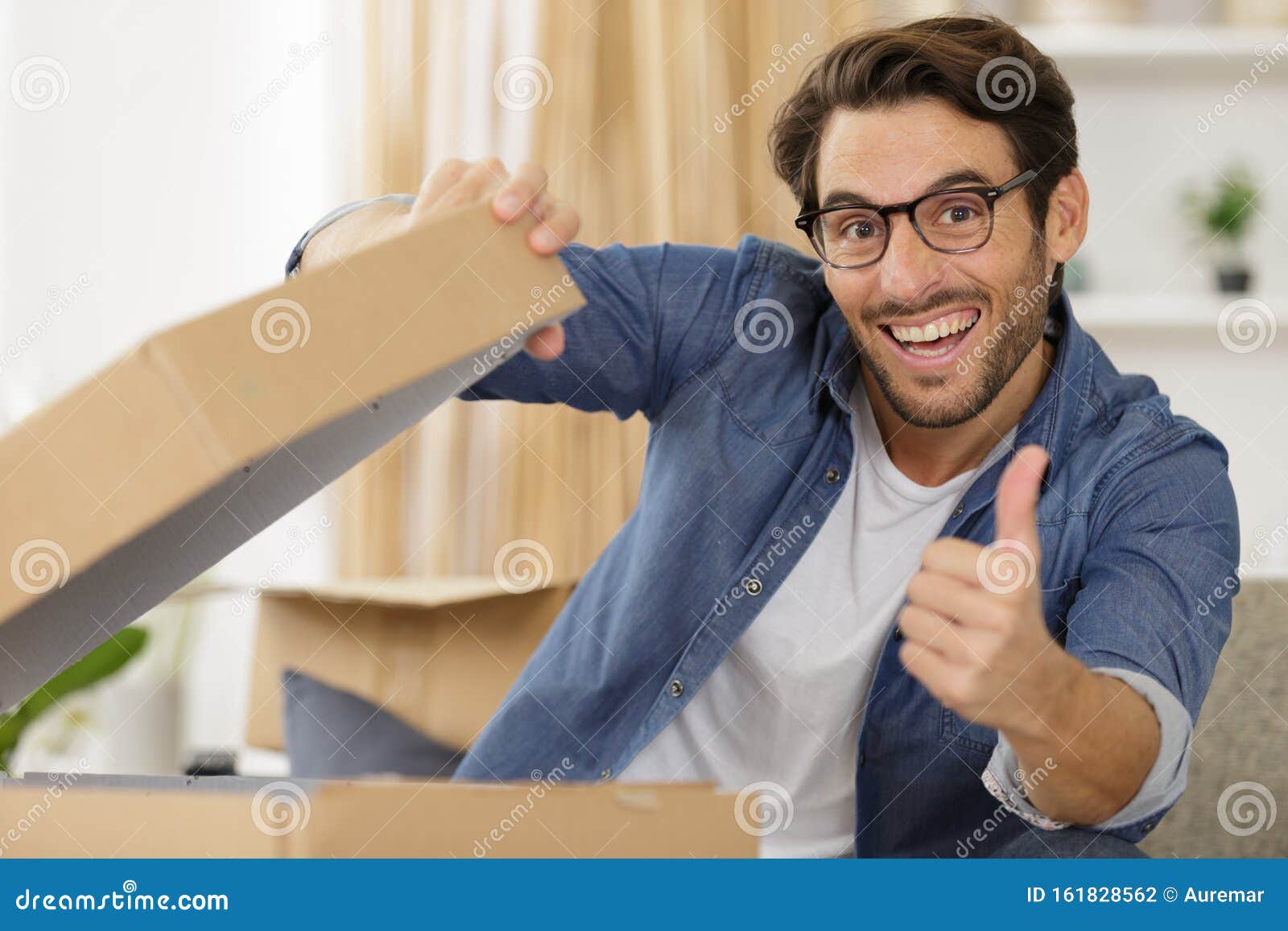 Happy Man Opening Parcel Box at Home Showing Thumb Up Stock Photo ...