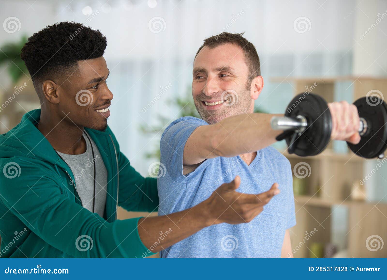 Happy Man Receiving Help by Male Physic Therapist Stock Photo - Image ...