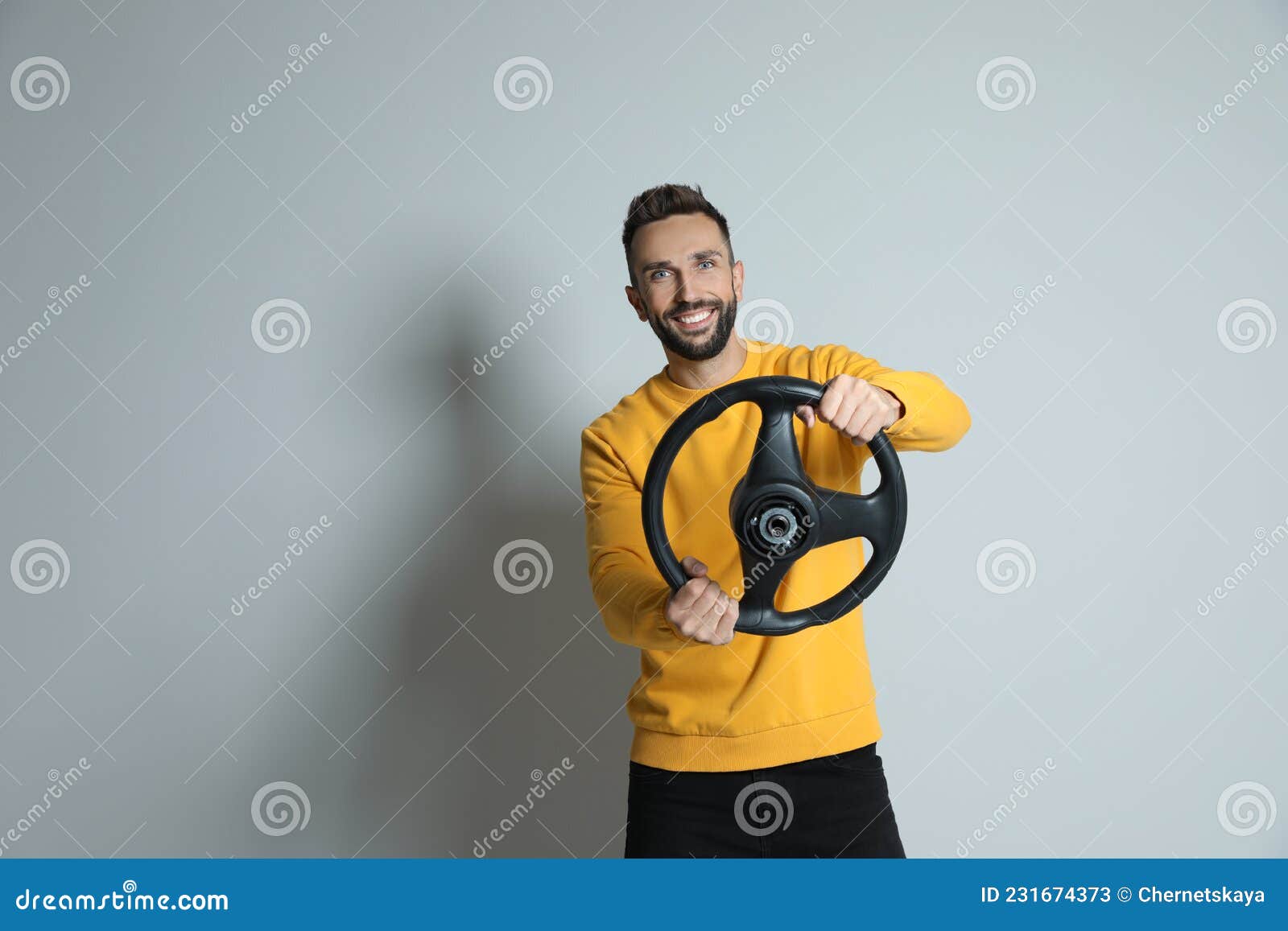 Happy Man with Steering Wheel on Grey Background Stock Image - Image of ...
