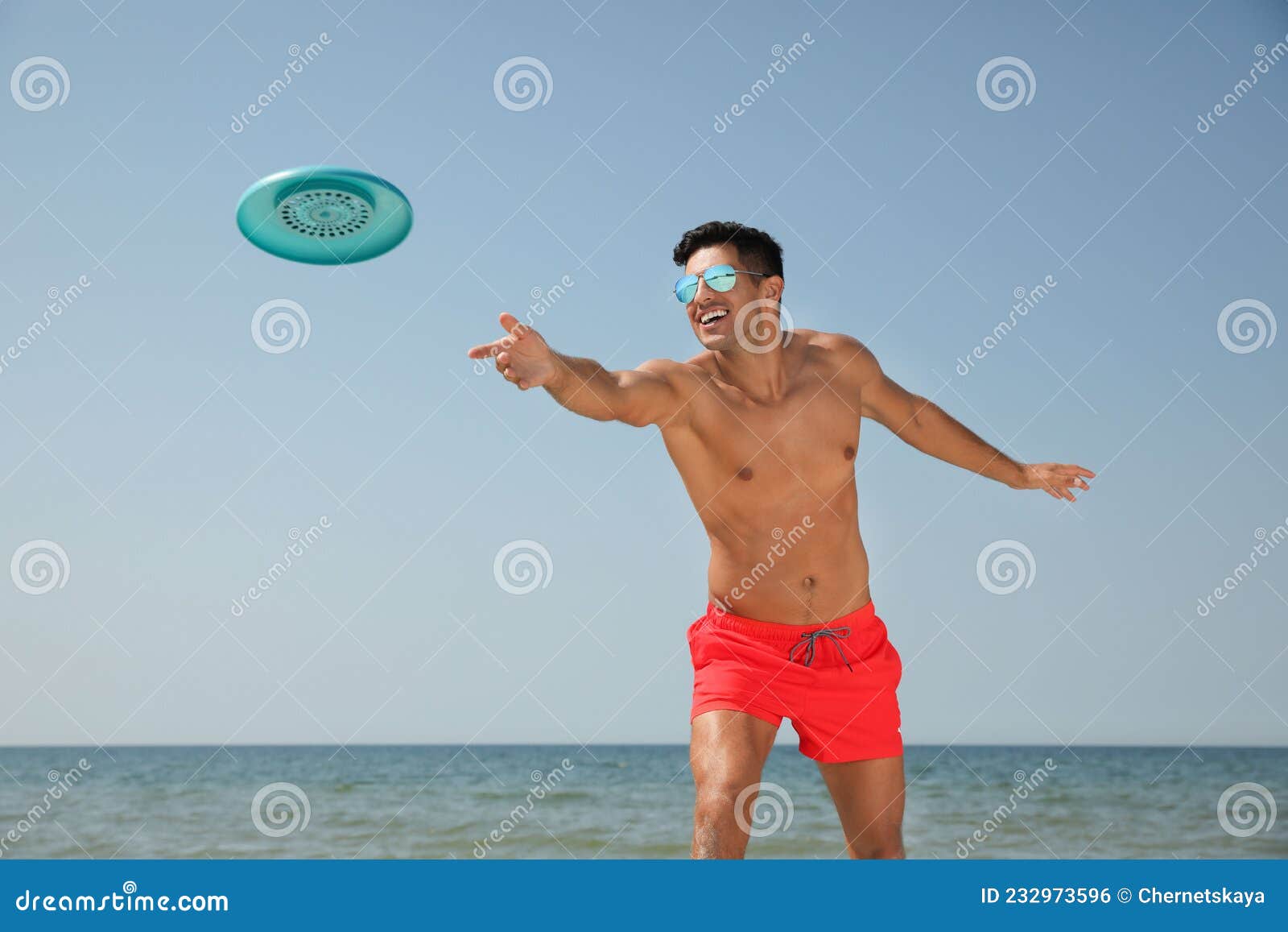 Happy Man Throwing Flying Disk at Beach on Sunny Day Stock Photo ...