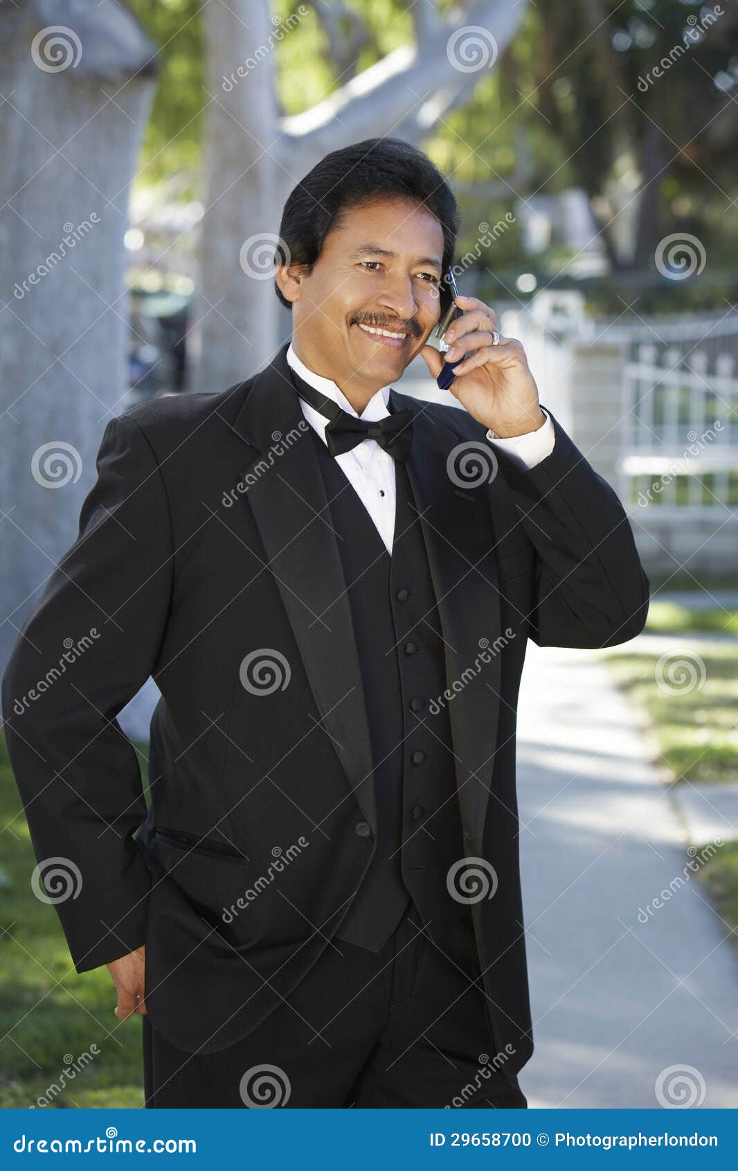 Happy Man in Tuxedo Using Cell Phone at Quinceanera Stock Photo - Image ...