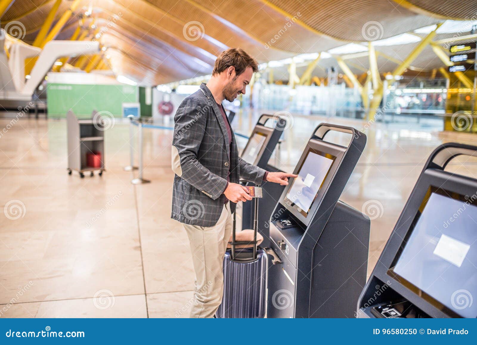 Happy Man Using the Check-in Machine at the Airport Getting the Stock ...