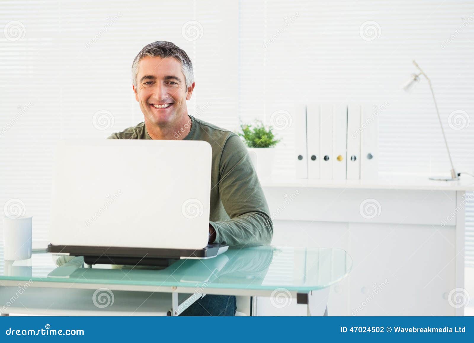 Happy Man Using His Laptop at Desk Stock Photo - Image of office, lamp ...