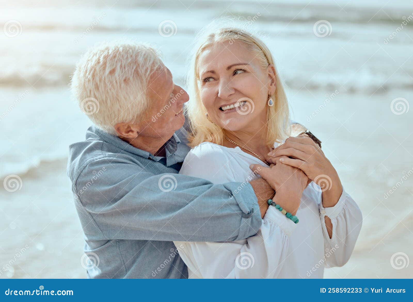 A Happy Mature Caucasian Couple Enjoying Fresh Air On Vacation At The Beach Smiling Retired