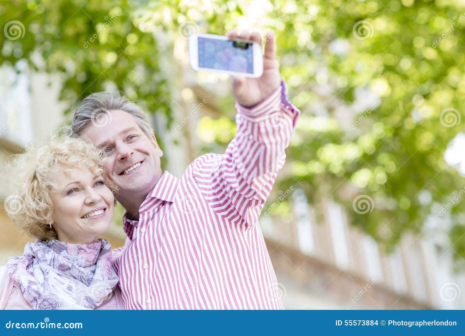 Happy Middle Aged Couple Taking Selfie Through Mobile Phone Outdoors