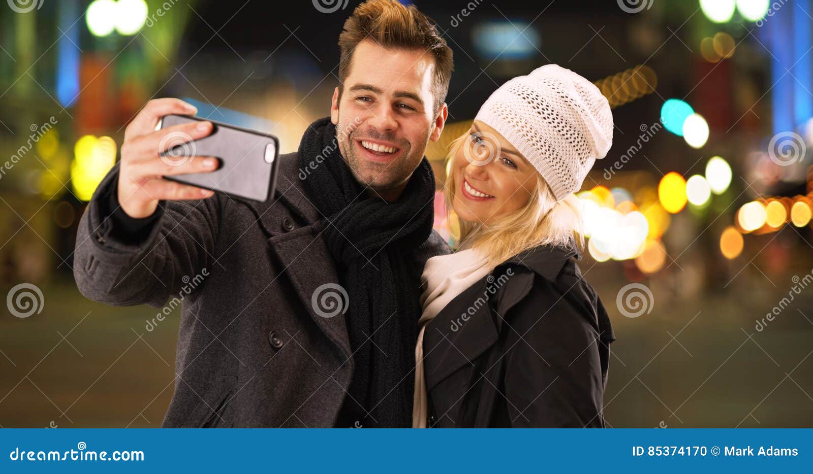 Happy Millenial Couple Having Fun Taking Selfies Together At Night In