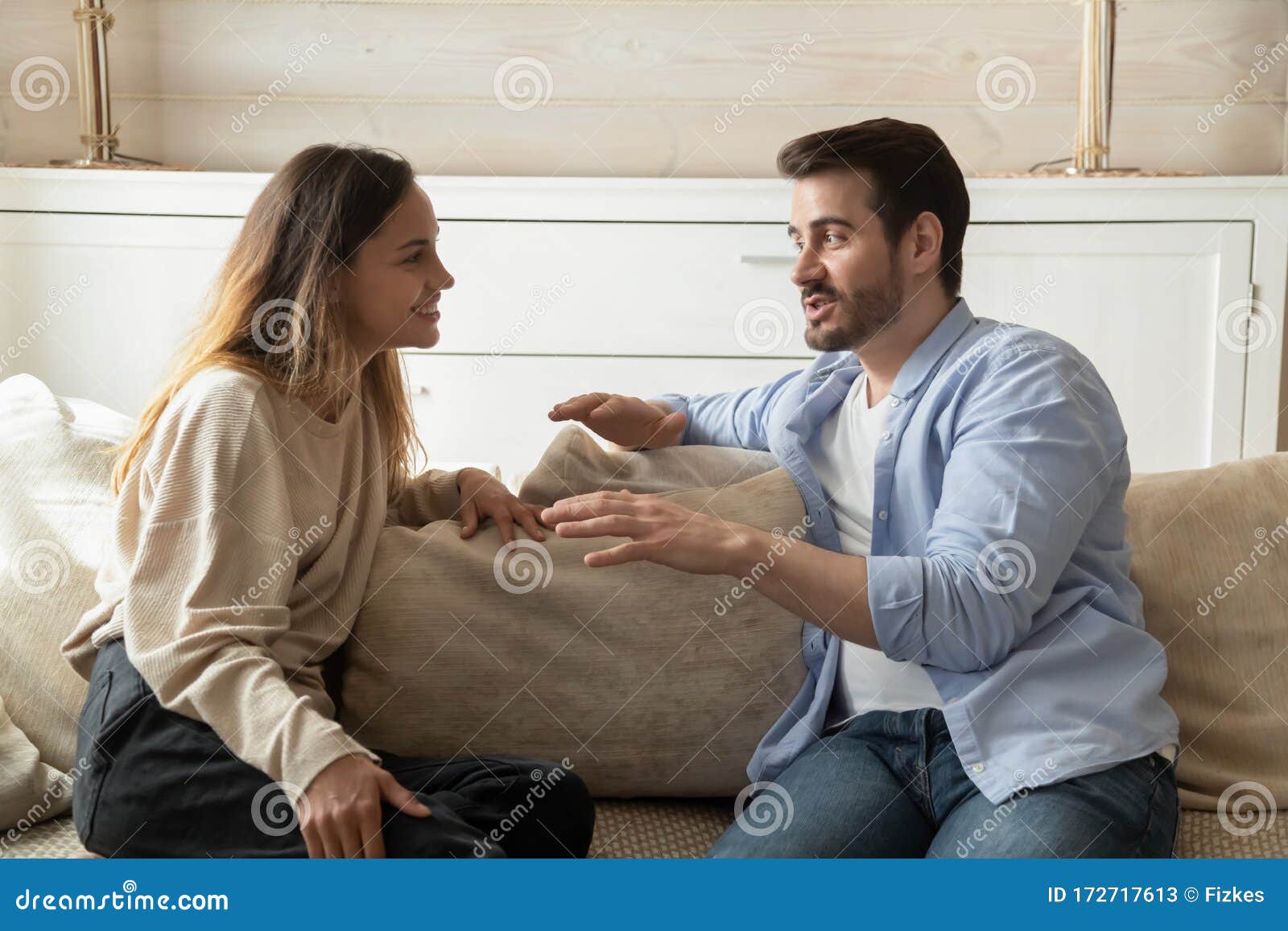 Happy Millennial Couple Talk Relaxing In Living Room Stock Image