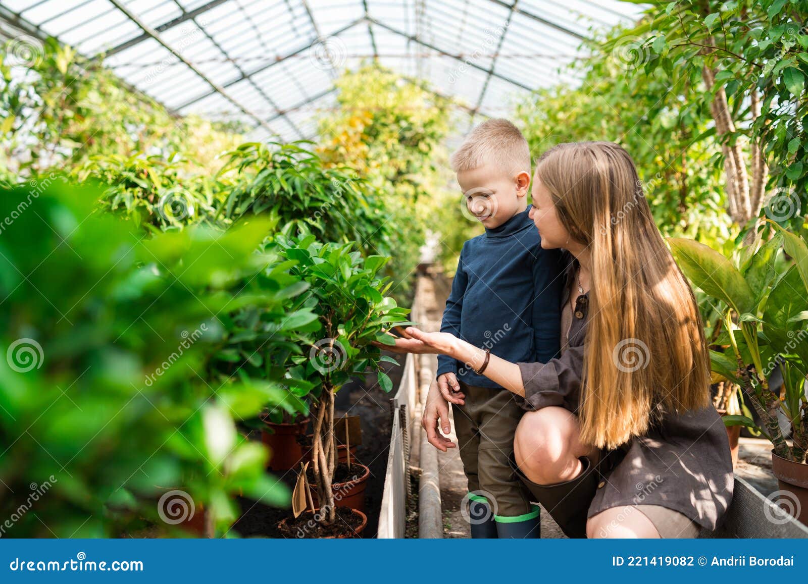Happy Mom with Her Son Showing Plants during a Greenhouse Excursion ...