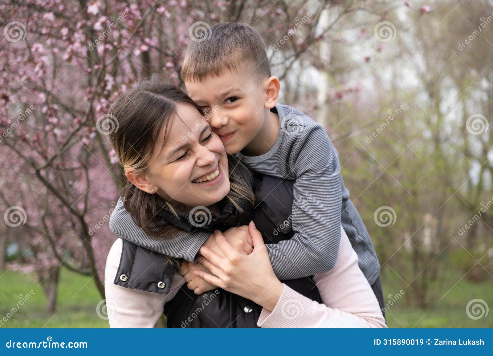 Happy Mom and Son Hugging among Cherry Blossoms in Spring. Stock Image ...