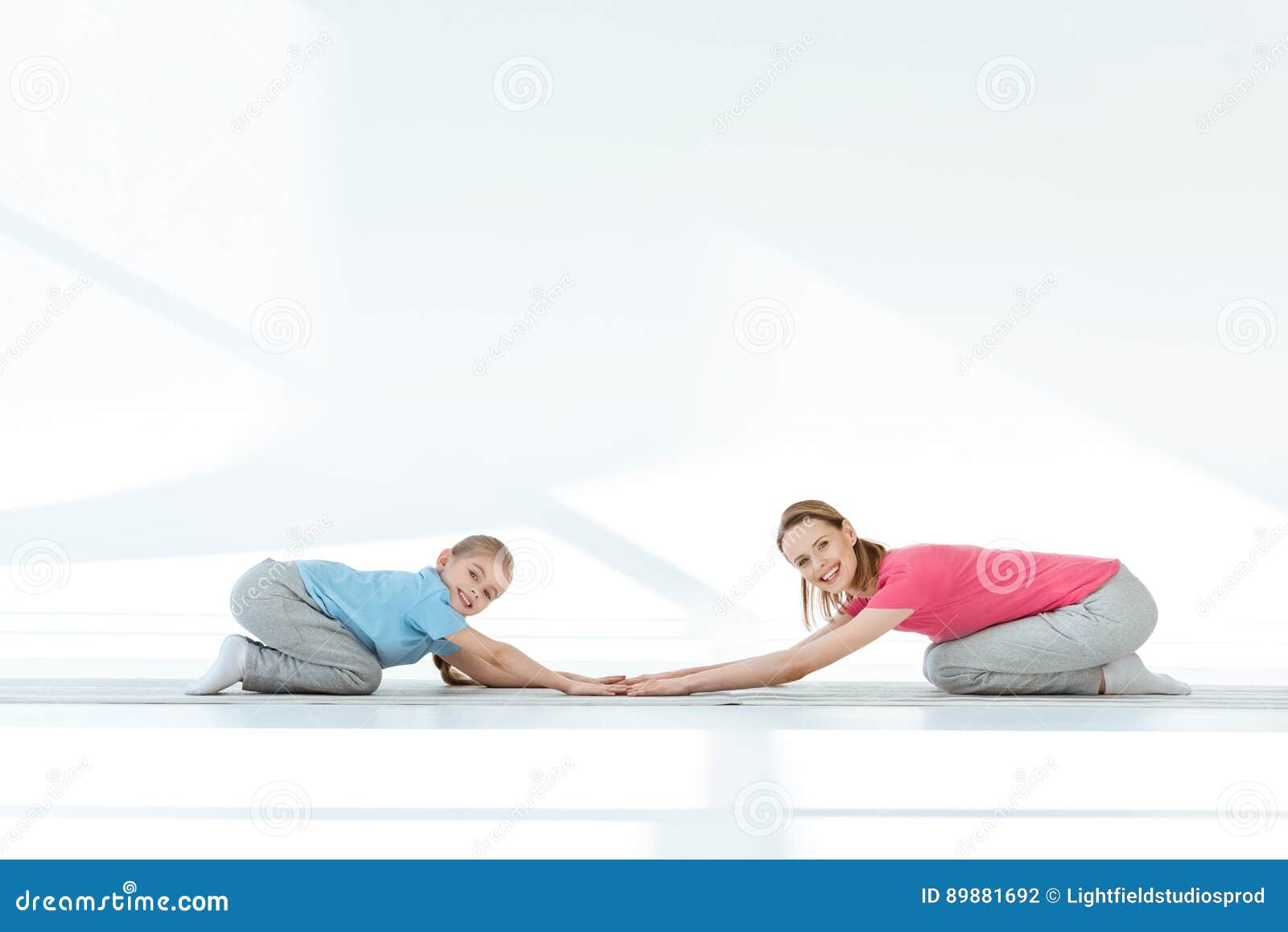 Happy Mother And Daughter In Sportswear Exercising On Yoga Mats Stock
