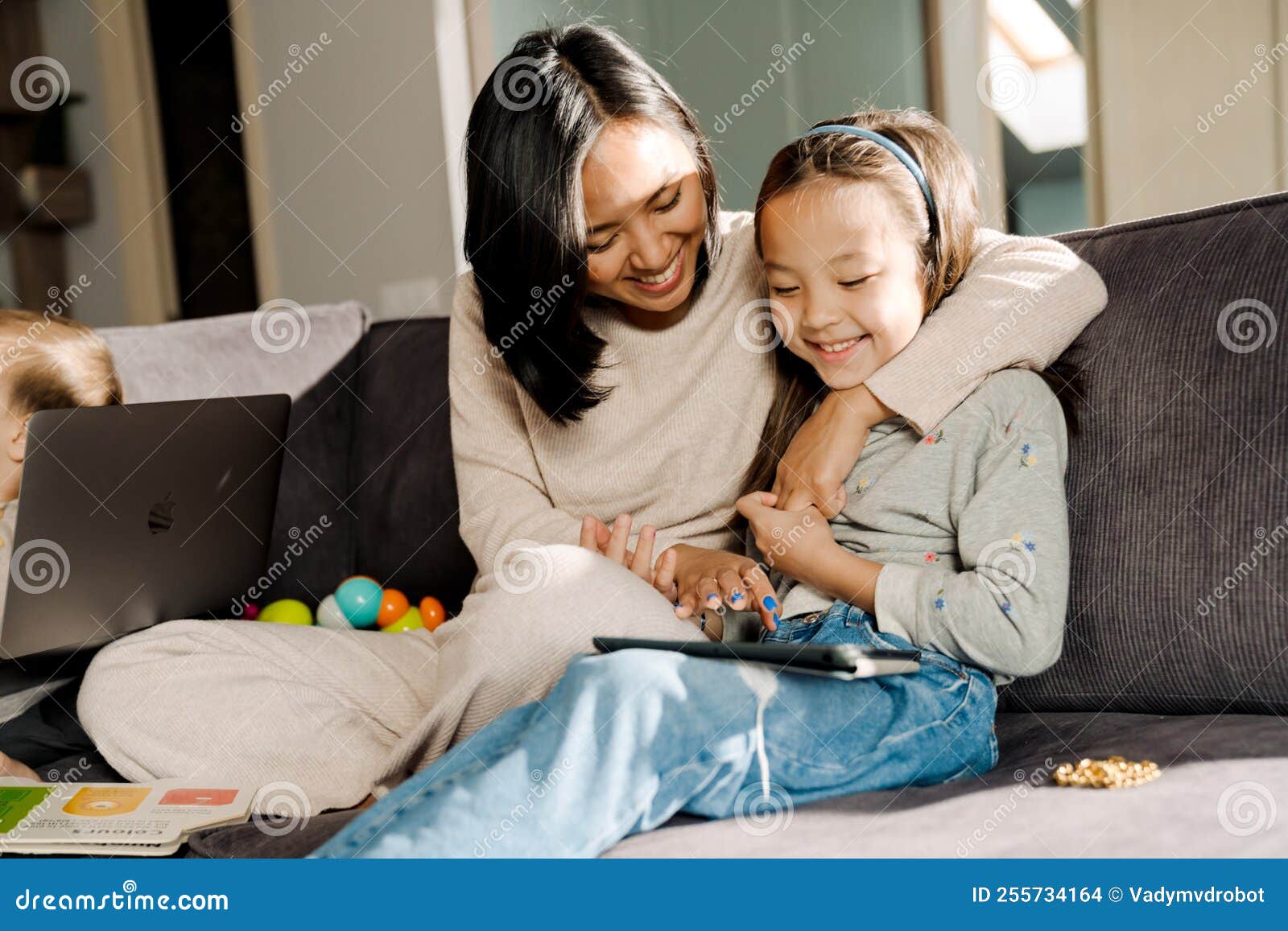 Happy Mother Using Tablet Computer while Hugging Her Daughter Stock ...