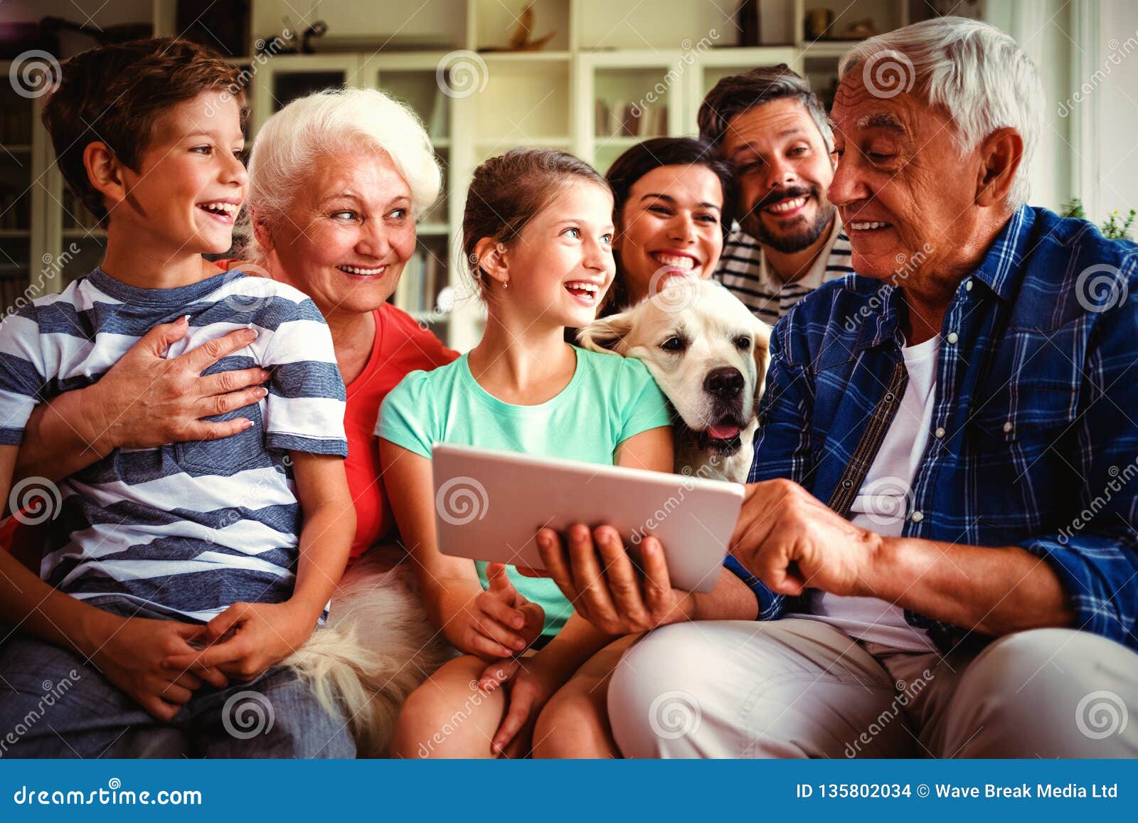 Happy Multi-generation Family Using Digital Tablet in Living Room Stock ...
