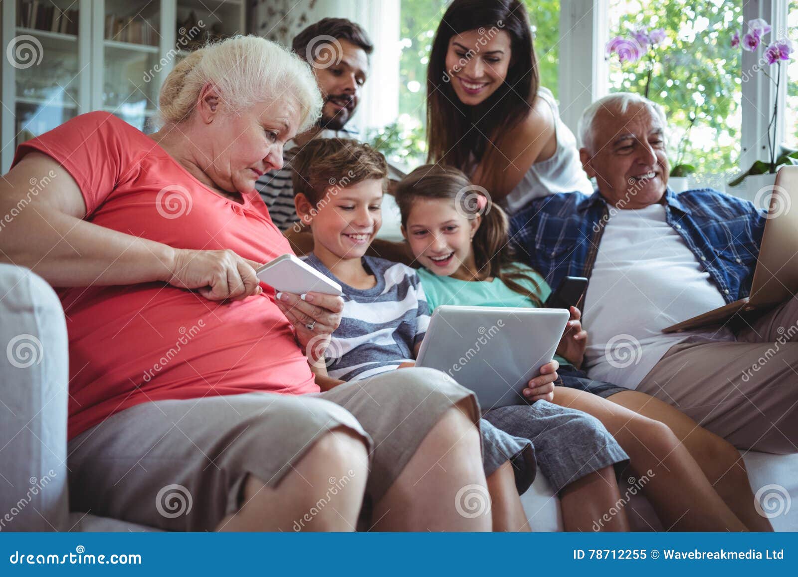 Happy Multi-generation Family Using Laptop, Mobile Phone and Digital ...