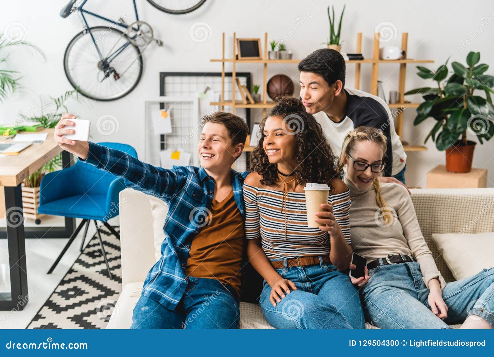 Happy Multiethnic Teenagers Sitting on Sofa and Taking Selfie Stock ... Happy Multiethnic Teenagers Sitting on Sofa and Taking Selfie Stock ...