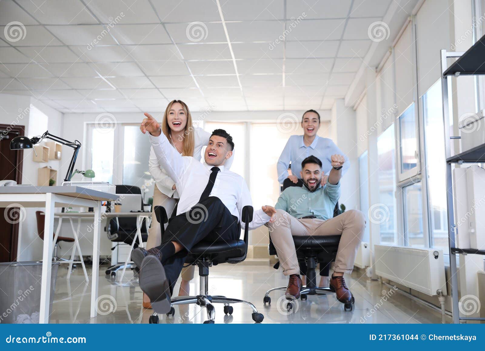 Happy Office Employees Riding Chairs at Workplace Stock Photo - Image ...
