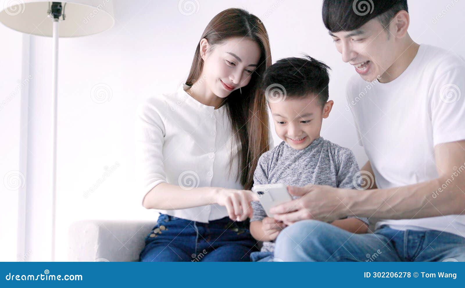 Happy Parent and Kid Using Mobile Phone, Resting on Home Couch Together ...
