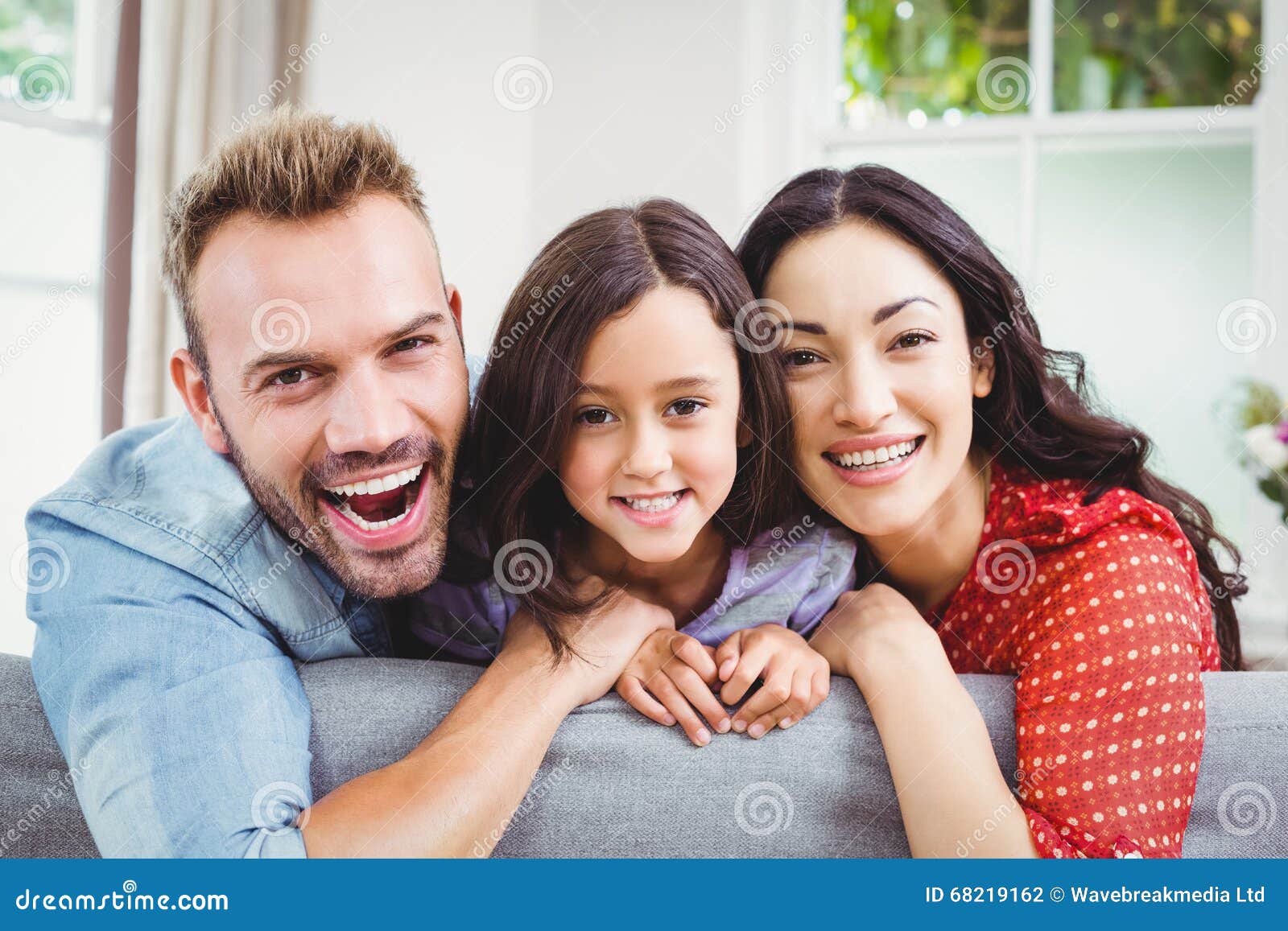 Happy Parents with Daughter on Sofa at Home Stock Photo - Image of ...