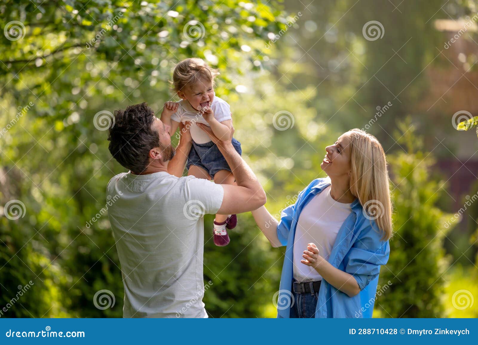 Happy Parents Spending Time Together with Their Kid Outdoors Stock ...