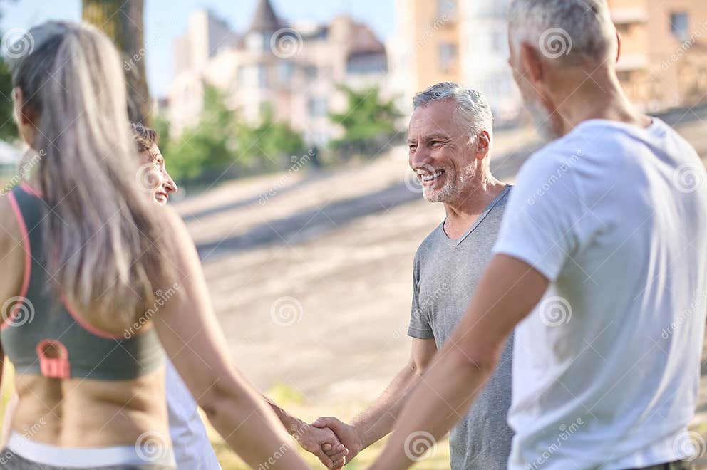 People Holding Hands and Looking Happy Stock Image - Image of maturity ...