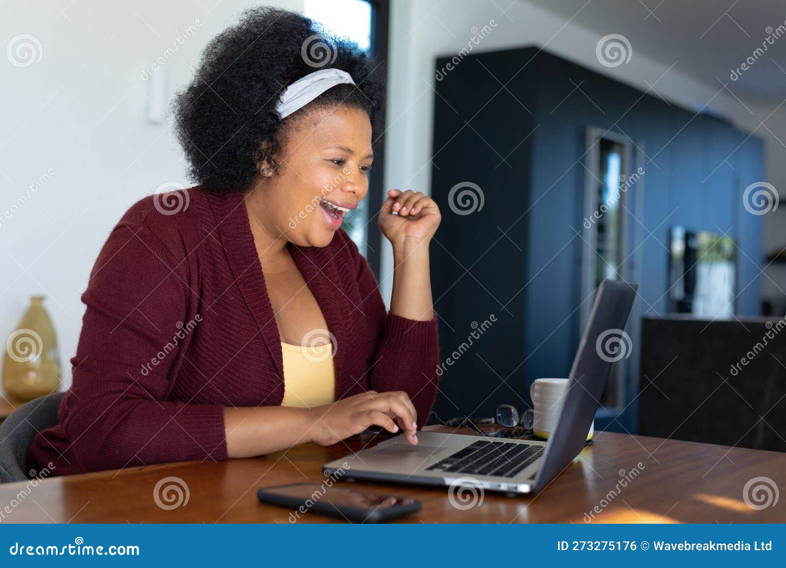 Happy Plus Size African American Woman Sitting At Table Making Video