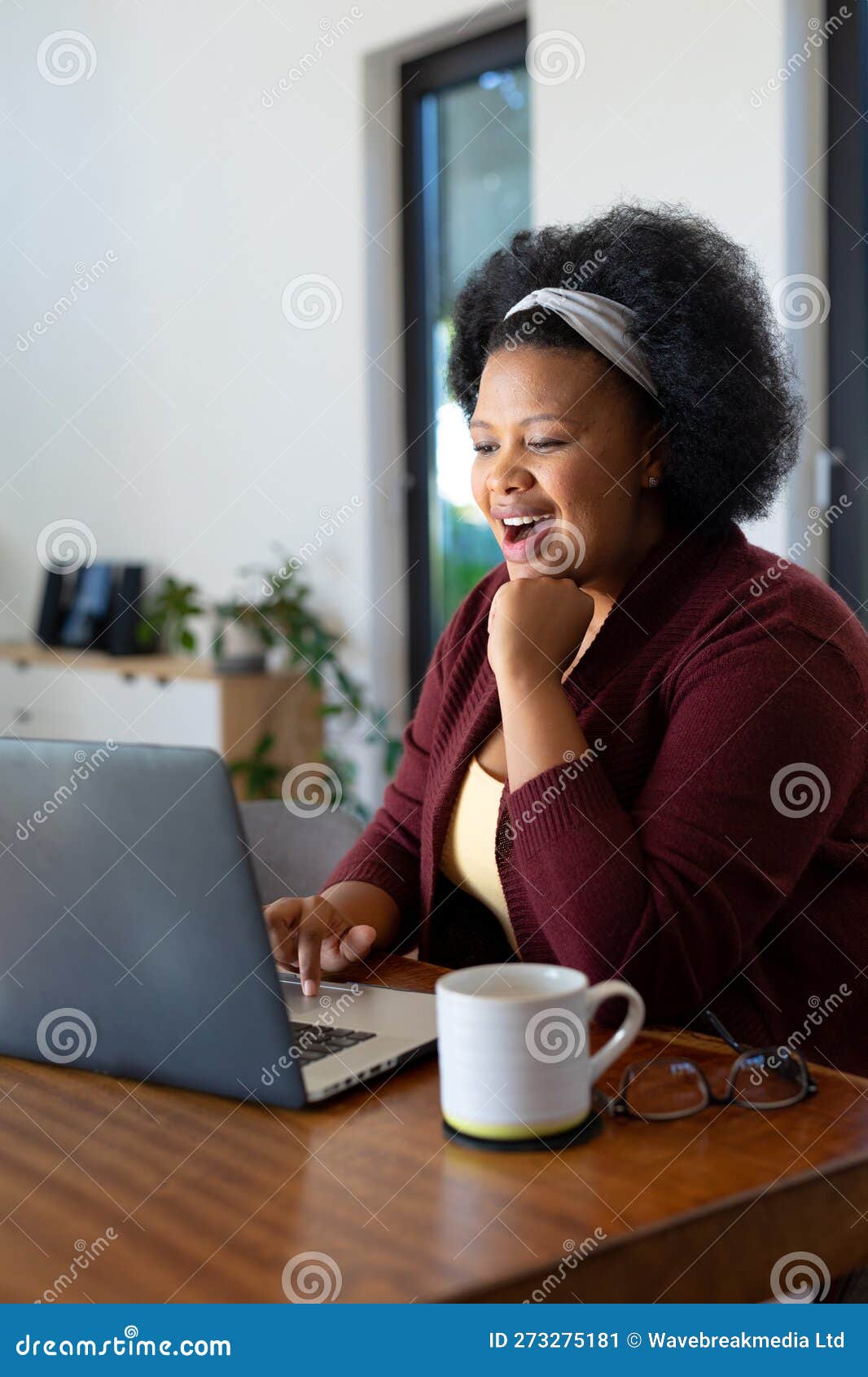 Happy Plus Size African American Woman Sitting At Table Making Video