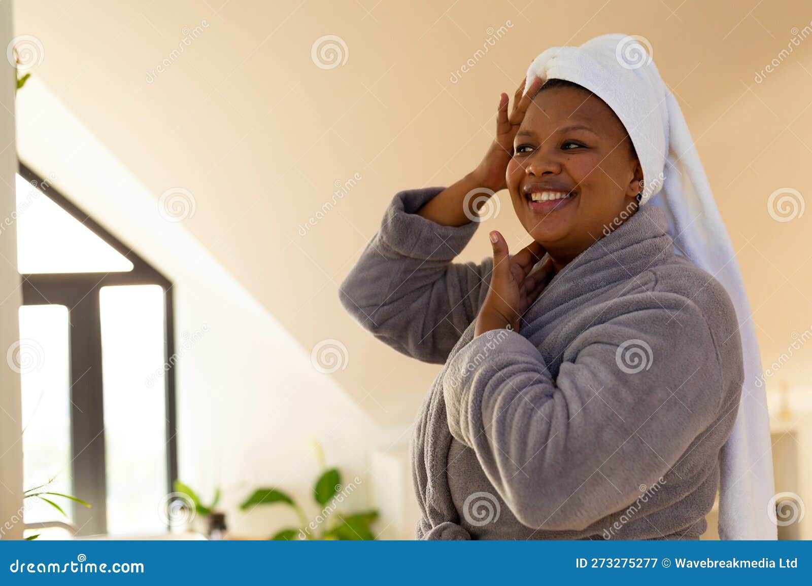 Happy Plus Size African American Woman Wearing Robe Looking At Herself