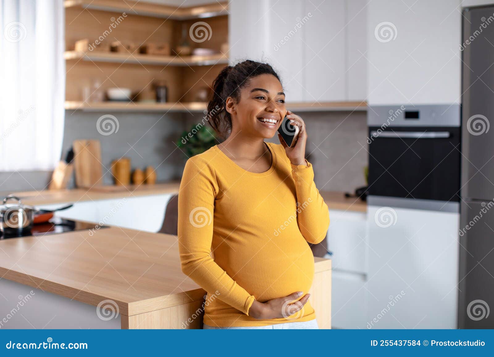 Happy Pretty Young Pregnant African American Woman Touching Belly And