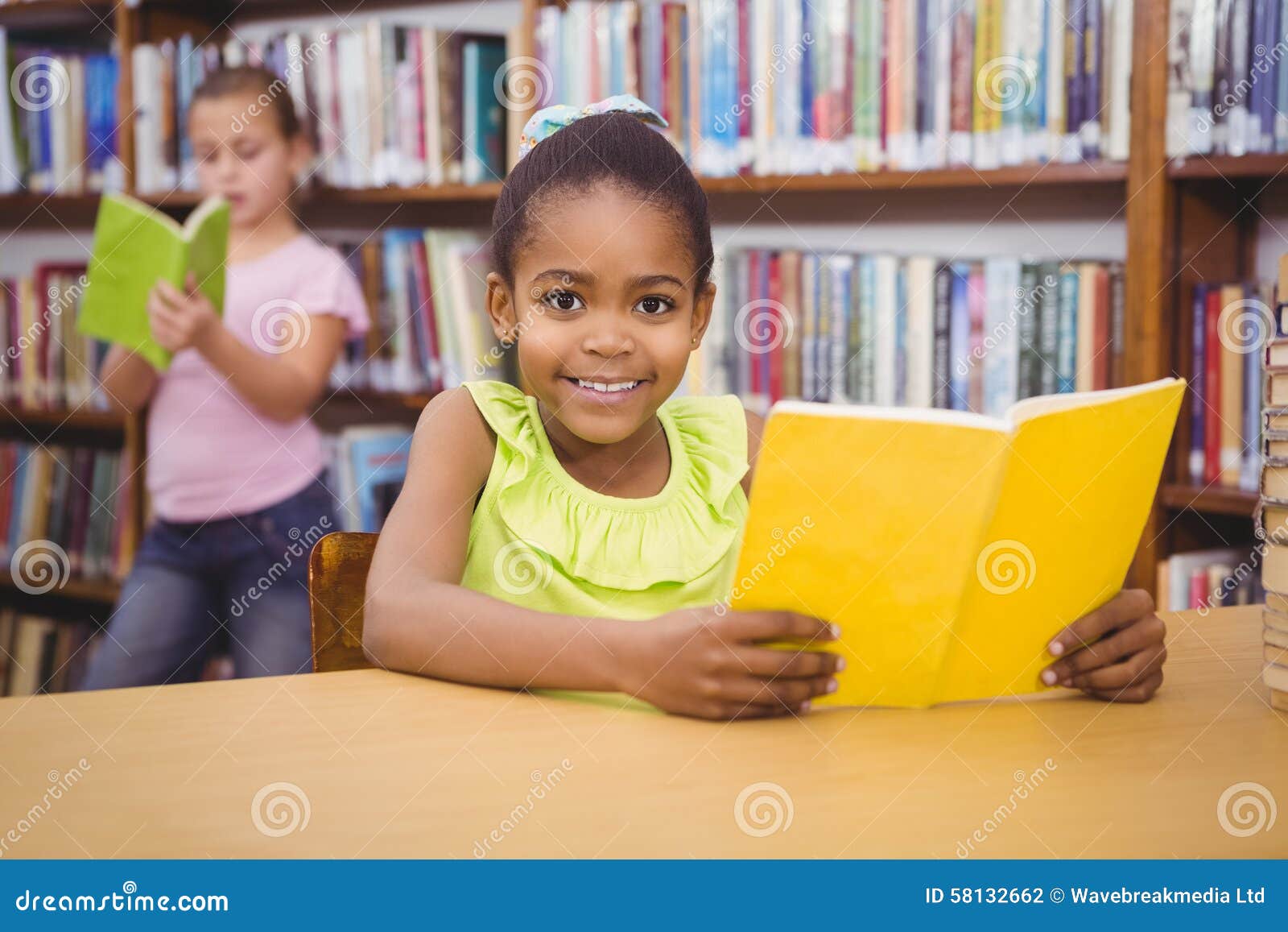 Happy Pupil Reading a Library Book Stock Photo - Image of desk ...
