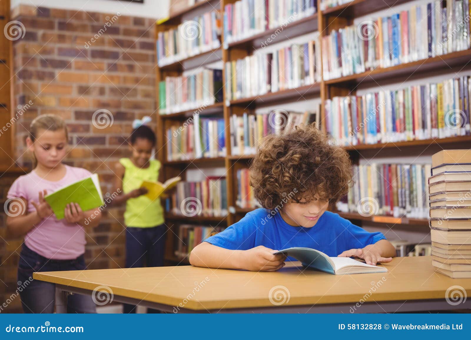 Happy Pupil Reading a Library Book Stock Photo - Image of development ...