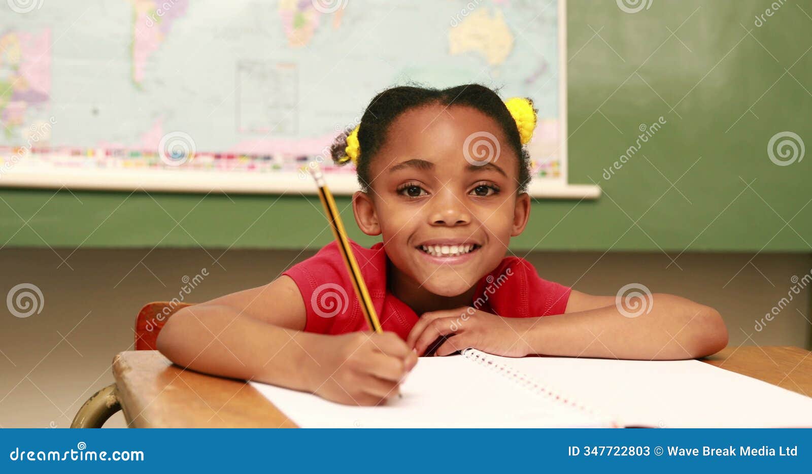 Happy Pupil Writing in Notepad at Desk at the Elementary School Stock ...