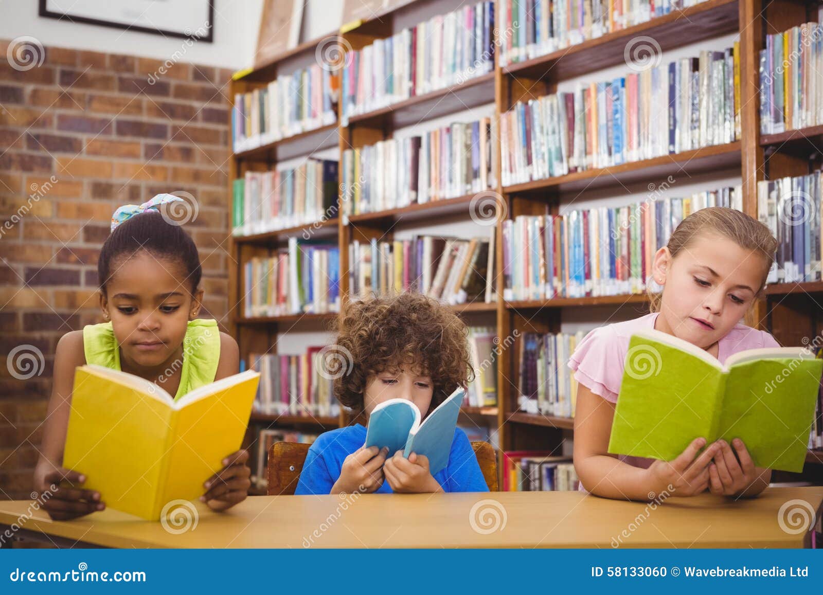 Happy Pupils Reading a Library Book Stock Photo - Image of development ...