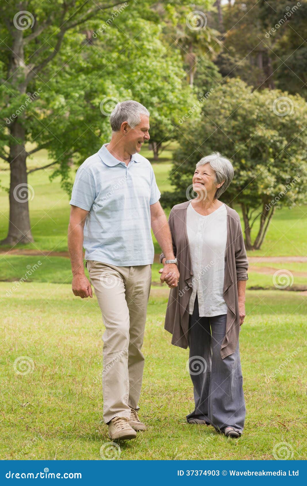Happy Senior Couple Holding Hands And Walking In Park Stock Image
