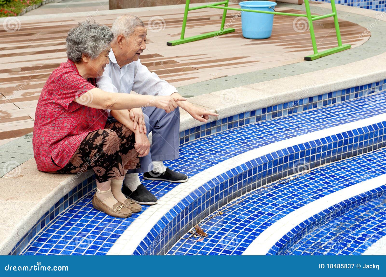 Happy Senior Couple Sitting beside a Pool Stock Image - Image of pair ...