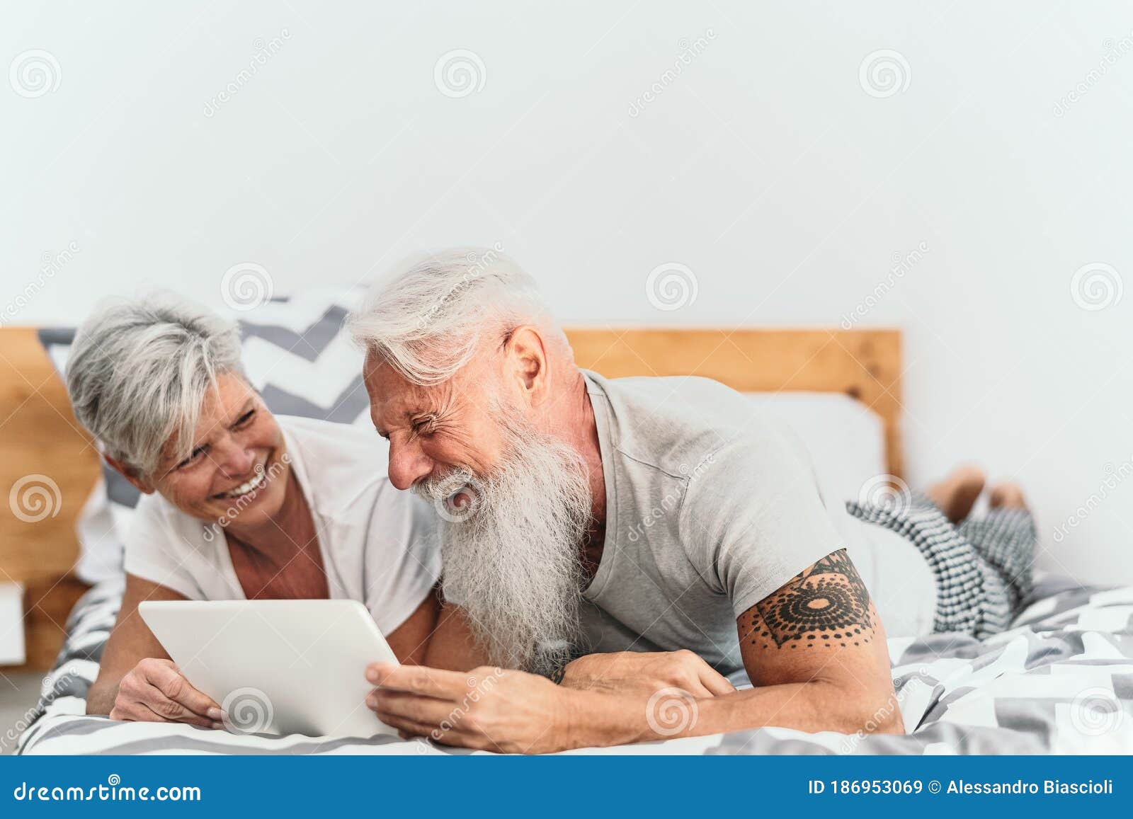 Happy Senior Couple Using Digital Tablet In Bed Mature People Having
