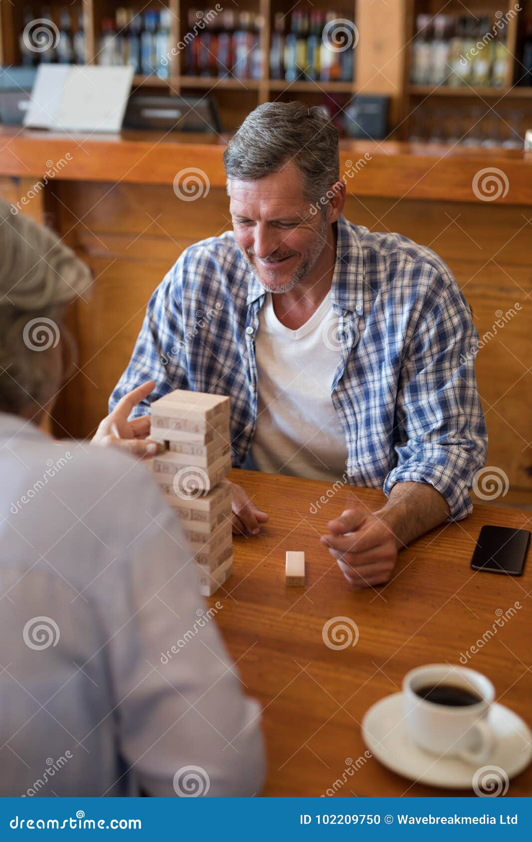 Senior Friends Playing Jenga Game on Table in Bar Stock Photo - Image ...