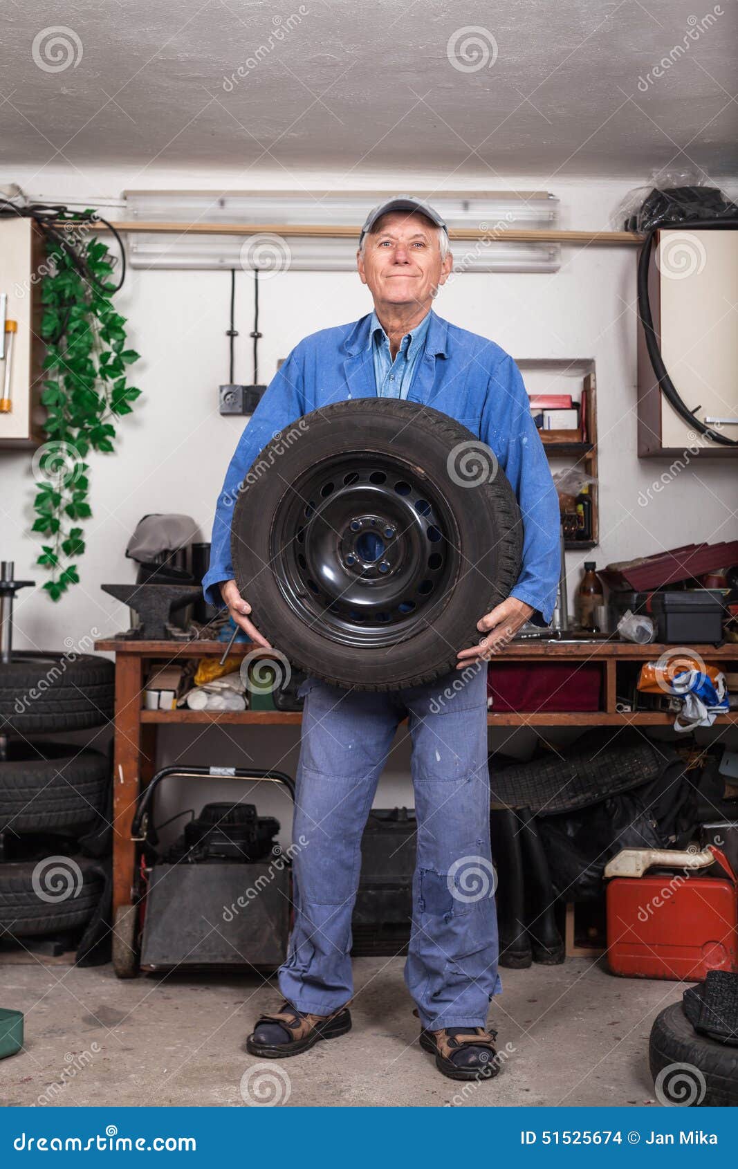Happy Senior Worker Changing Tire in Garage Stock Photo - Image of ...