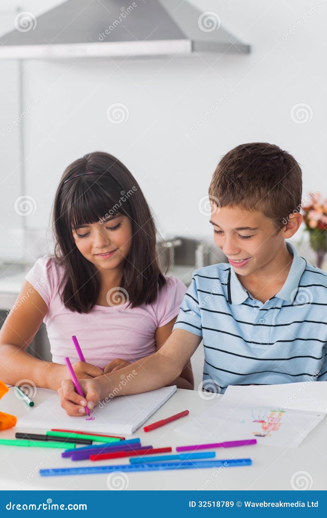Siblings Drawing Together In Kitchen With Their Parents Smiling Stock ...