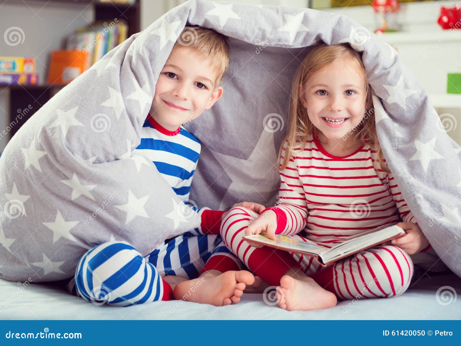 Happy Siblings Reading Book Under Cover Stock Photo - Image of brother ...