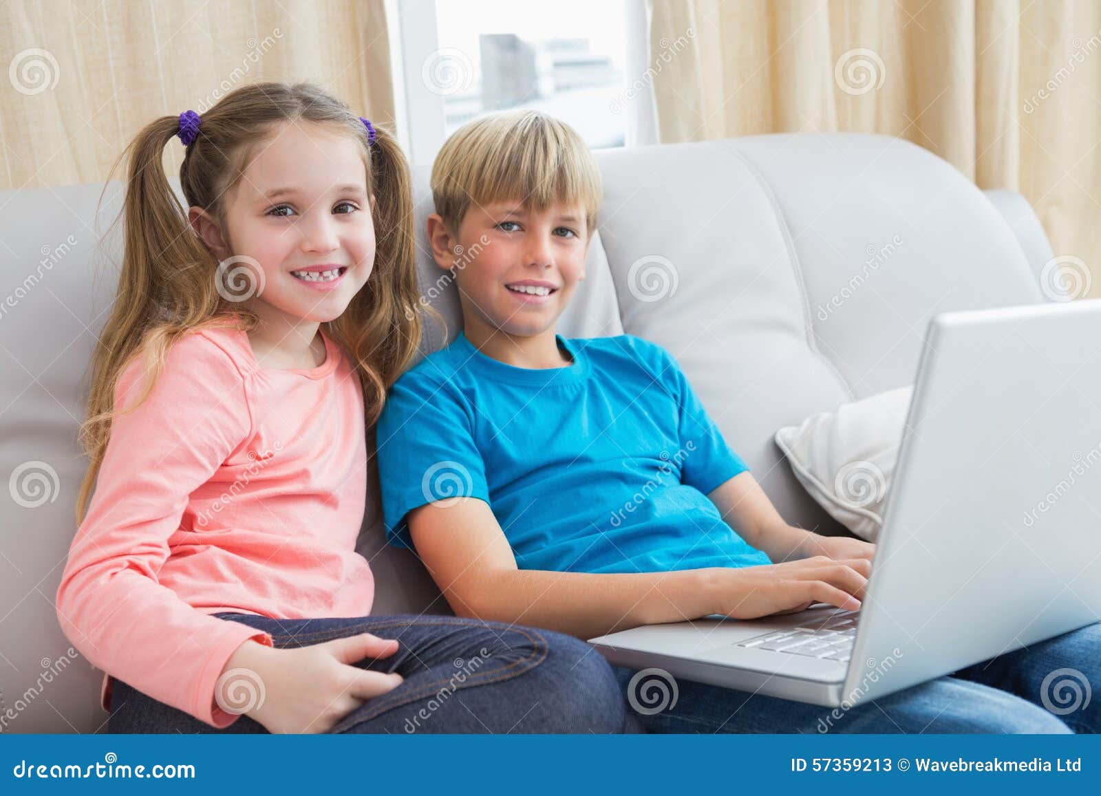Happy Siblings Using Laptop on Sofa Stock Image - Image of looking ...