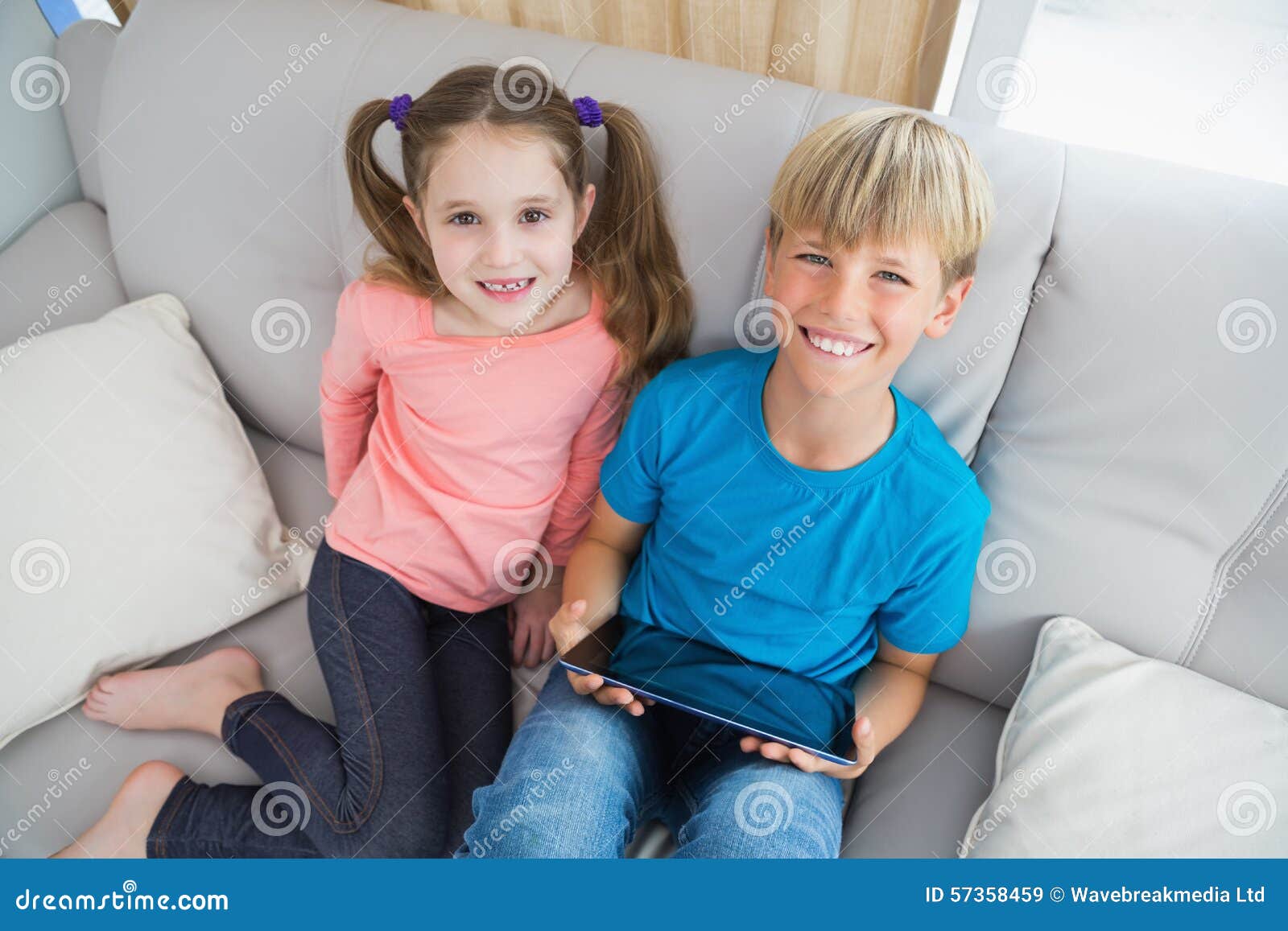 Happy Siblings Using Tablet Pc on Sofa Stock Image - Image of leisure ...