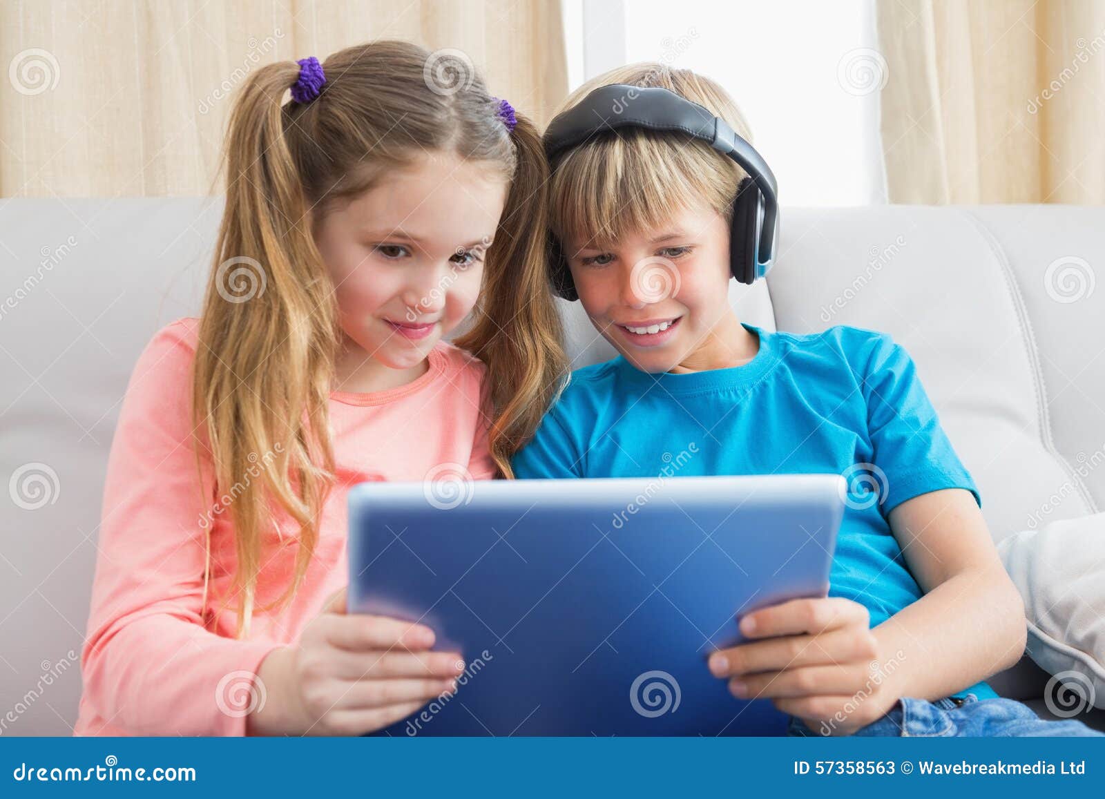 Happy Siblings Using Tablet Pc on Sofa Stock Image - Image of childhood ...
