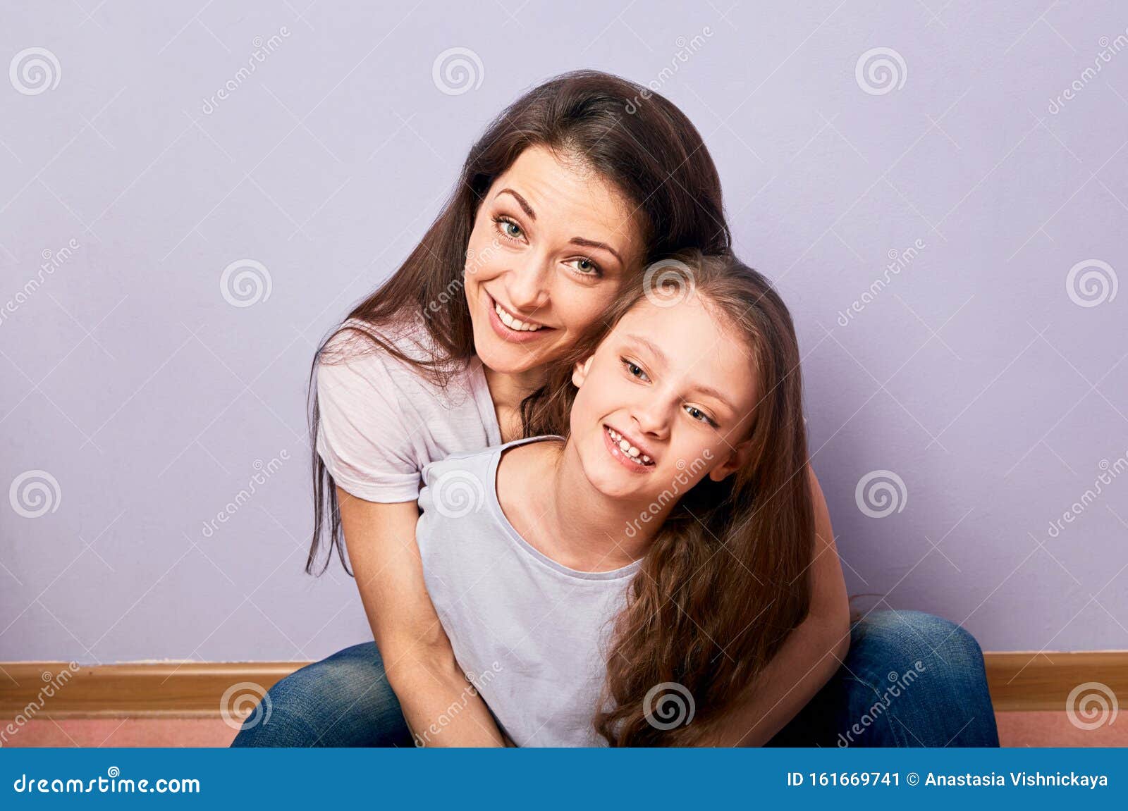 Happy Smiling Emotion Mother Cuddling Her Cute Daughter Sitting On The