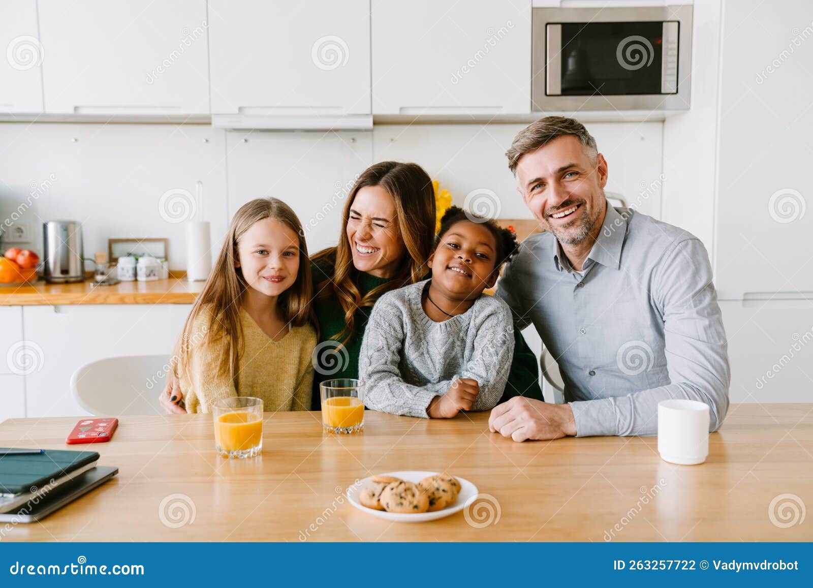 Happy Smiling Family Sitting at the Kitchen Table at Home Stock Photo ...