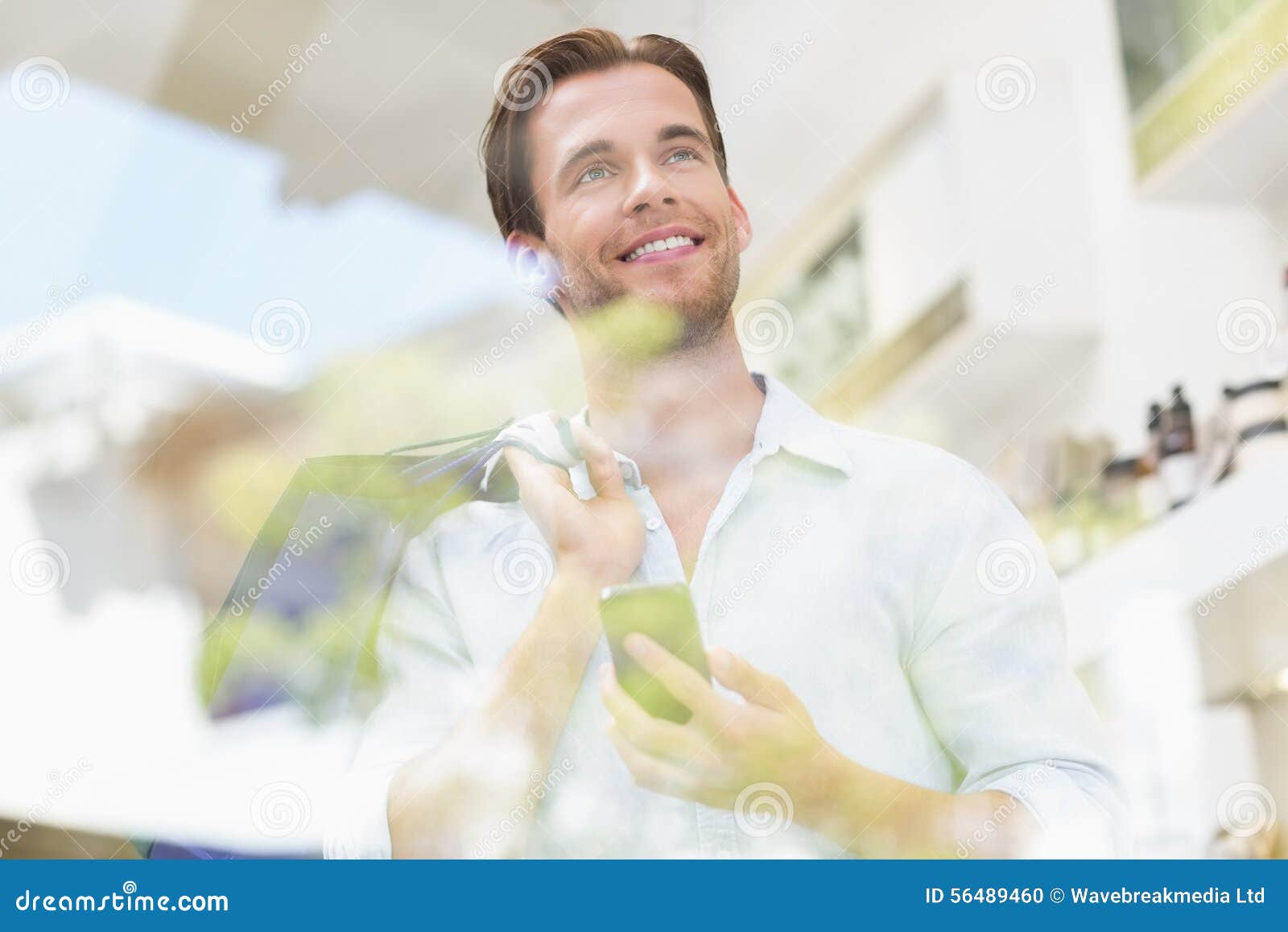 A Happy Smiling Man Looking at the Phone Stock Photo - Image of light ...