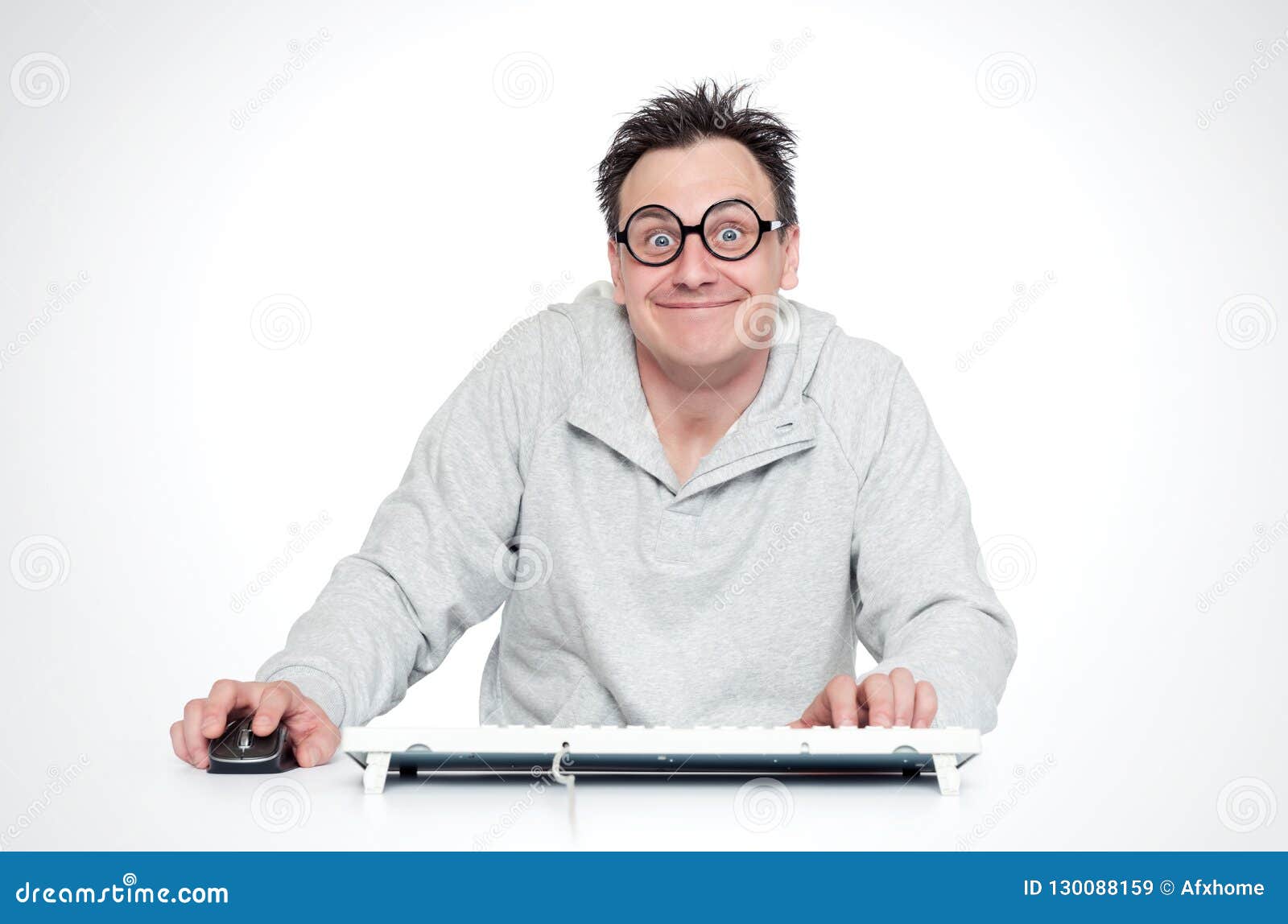 Happy Smiling Man in Round Glasses Sits at a Table with a Keyboard and ...