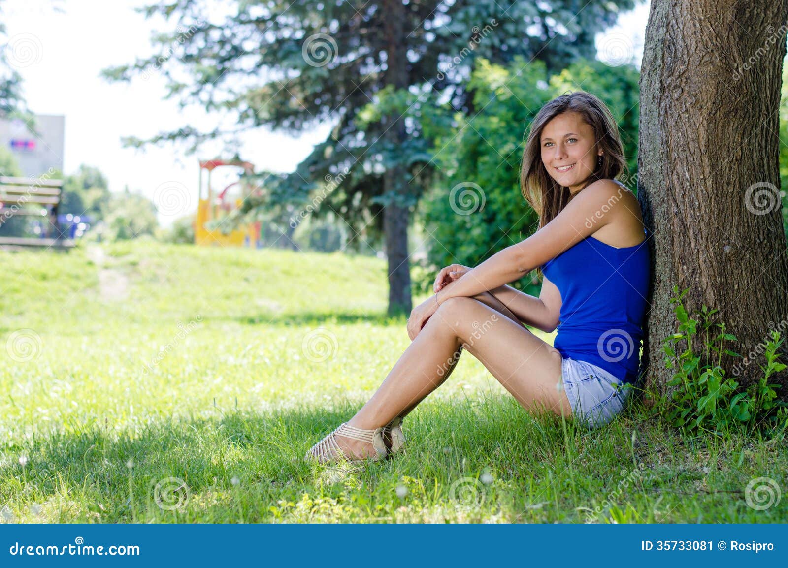 Happy Smiling School Girl Sitting At Tree In Park On Summer Day Stock